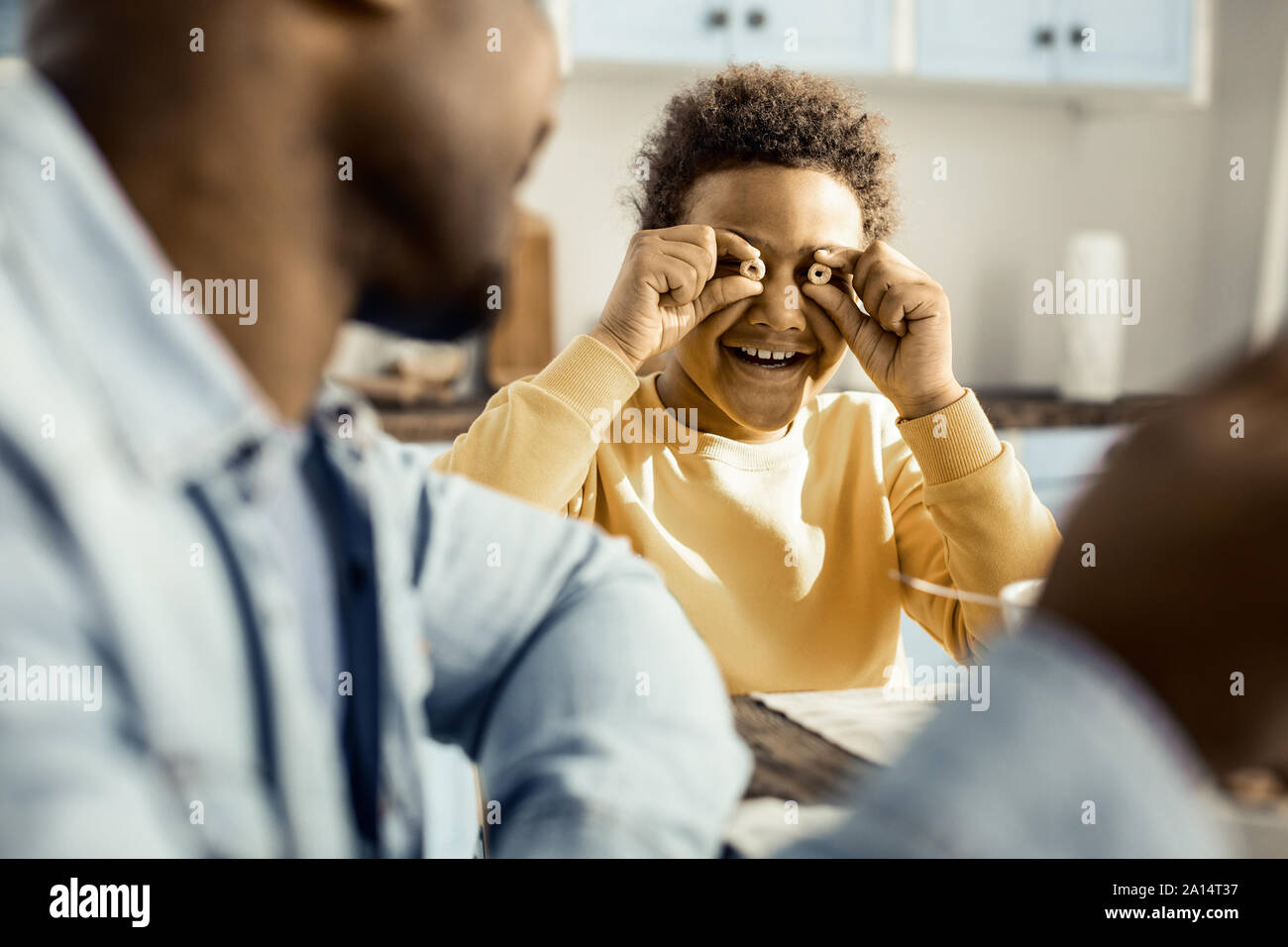 Happy child looking at dad through corn rings and laughing Stock Photo ...