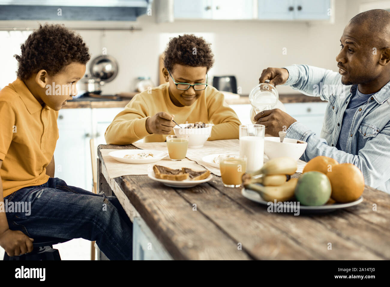 Dad preparing breakfast for his sons and finally sitting down to eat ...