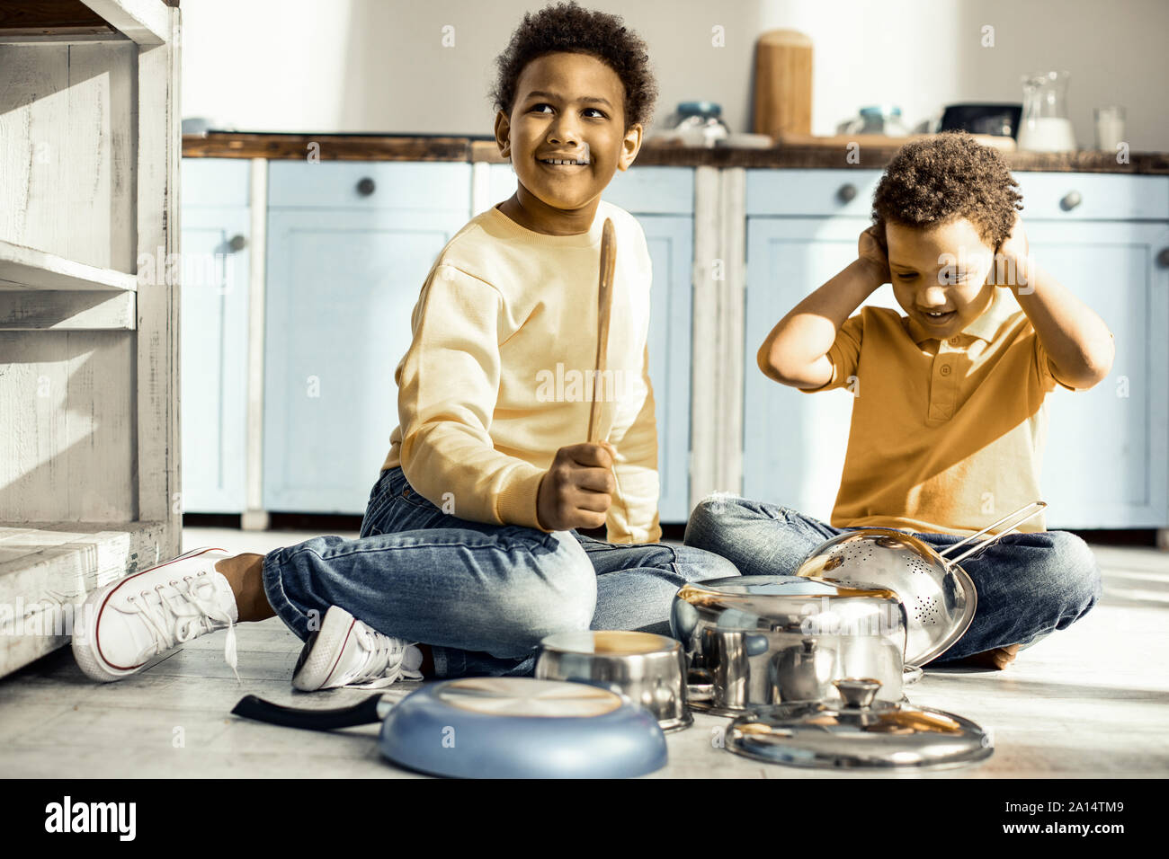 Boy covering ears while his brother trying to play on the dishes Stock ...