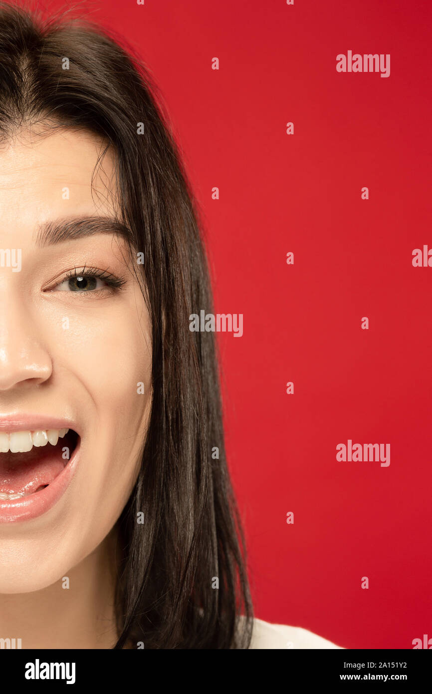 Caucasian young woman's close up portrait on red studio background ...