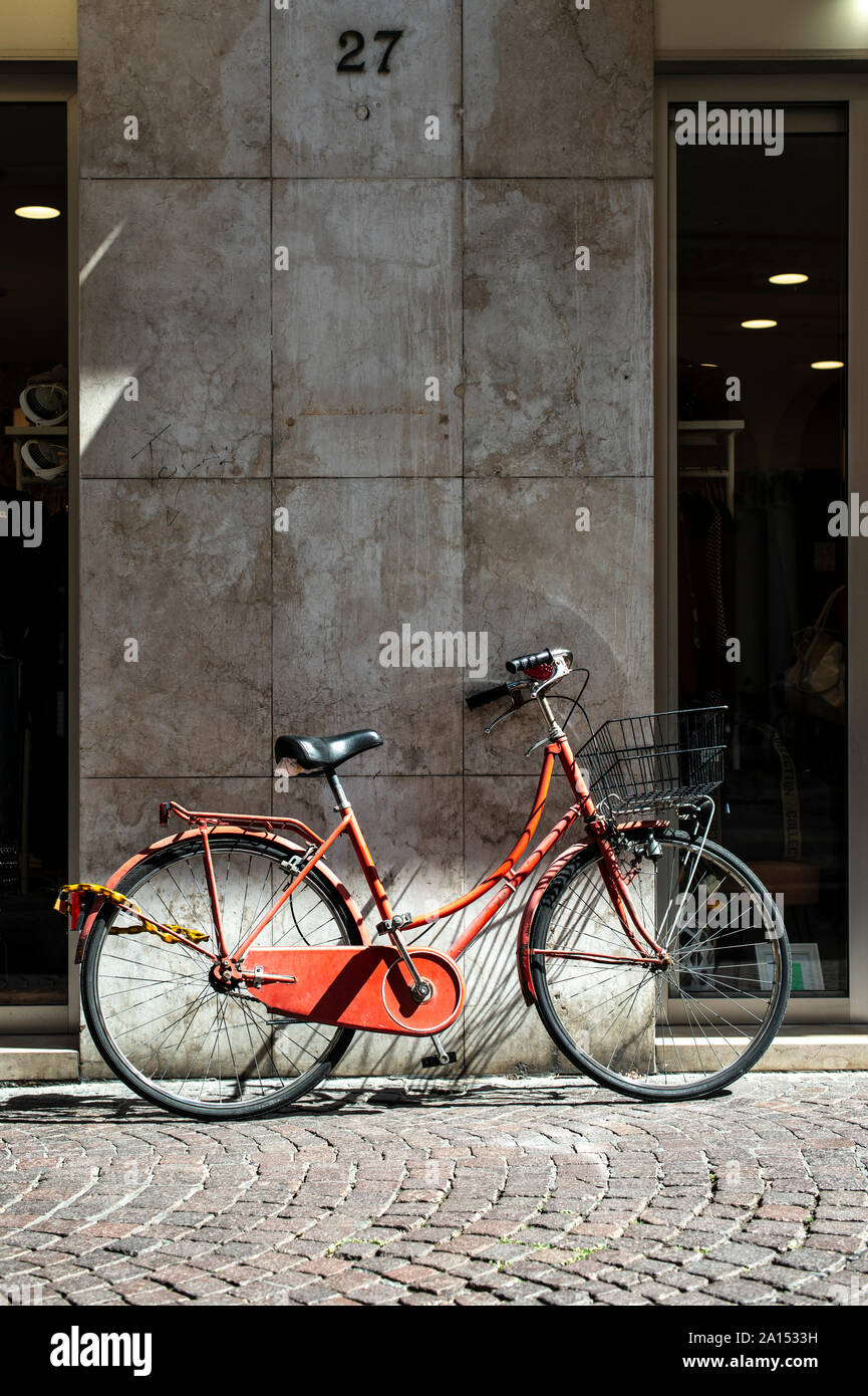 Red bike with basket on italian street. Typical italian architecture on ...