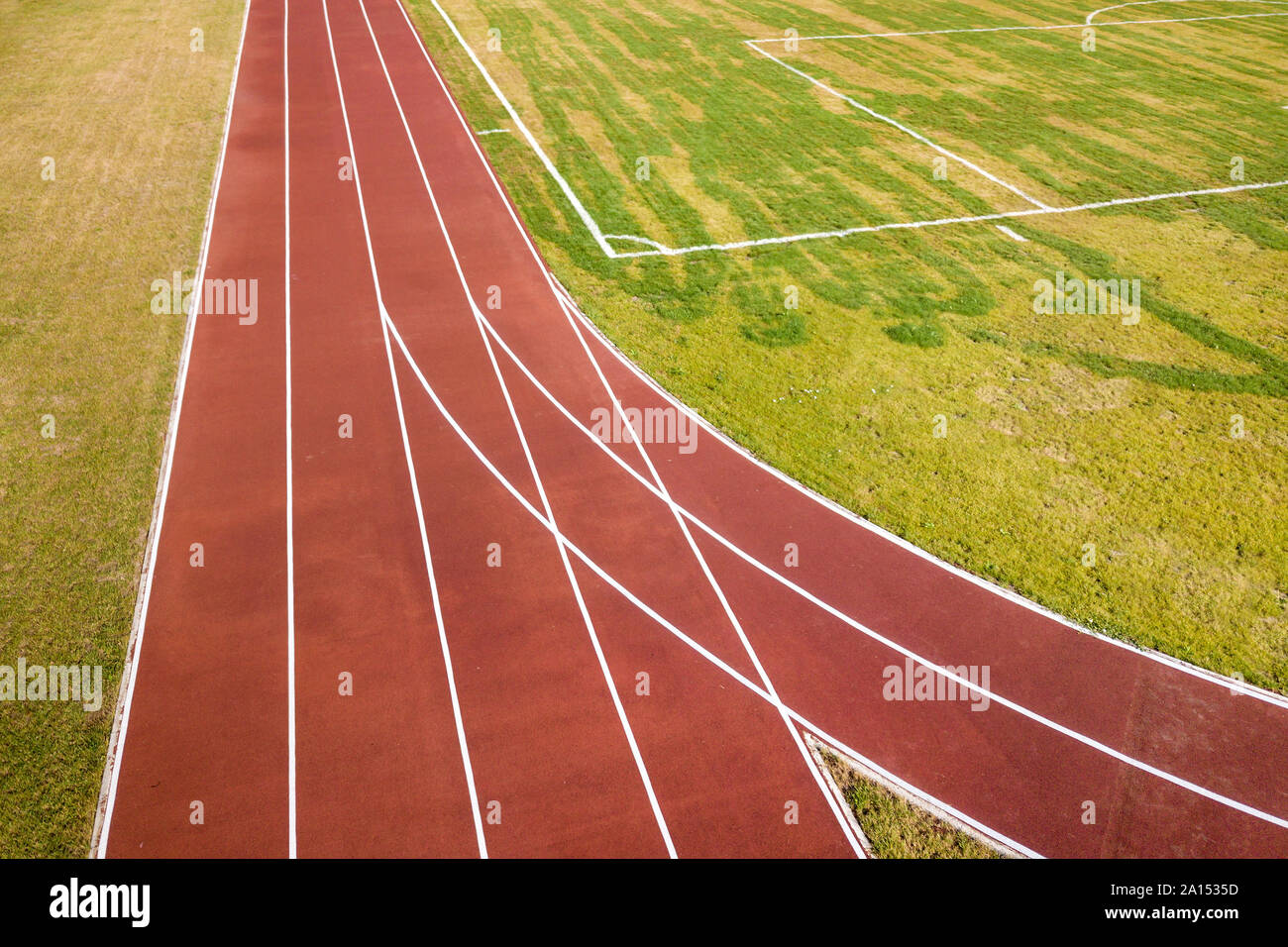 Top view of red running tracks and green grass lawn. Infrastructure for ...