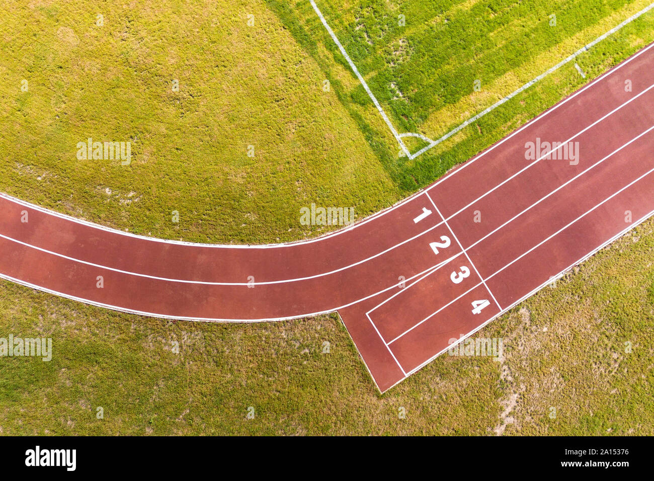 Top view of red running tracks and green grass lawn. Infrastructure for ...