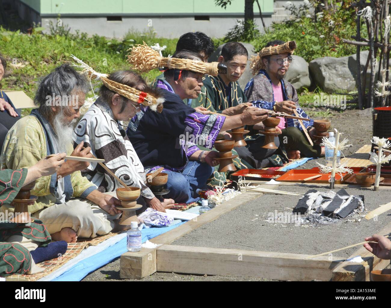 People perform a traditional Ainu ceremony, praying and offering food ...