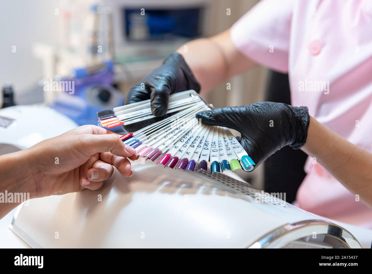 Professional cosmetologist shows color palette of manicure with gel ...