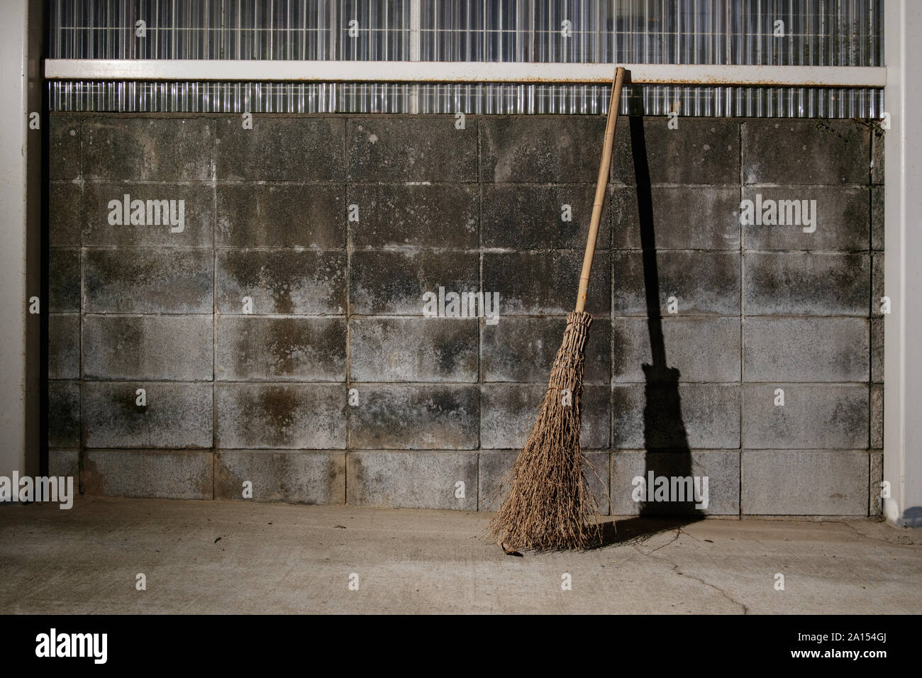 old-fashioned asian bamboo broom leaning against a wall Stock Photo - Alamy