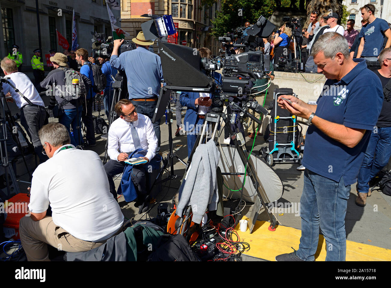 Ben Brown, BBC news presenter (sitting, left) and other TV crews and ...