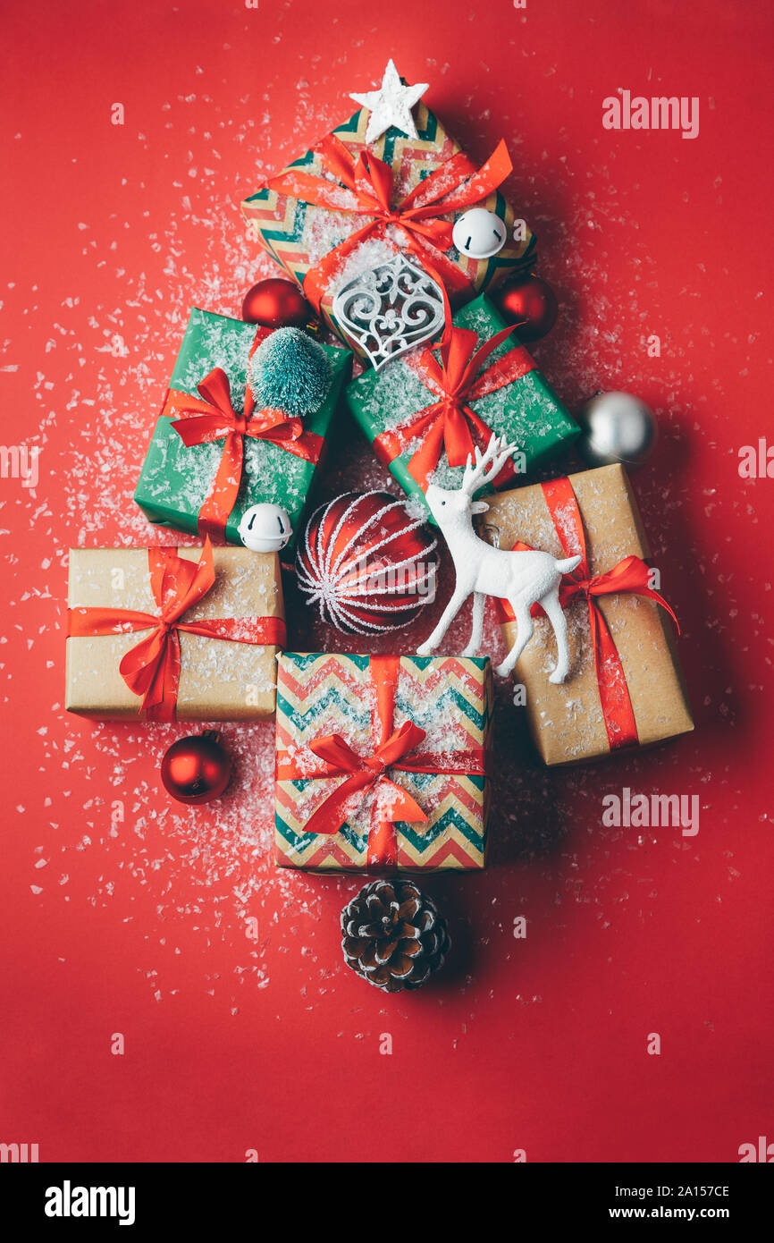 Christmas tree made with gift boxes and Christmas ornaments on a red ...