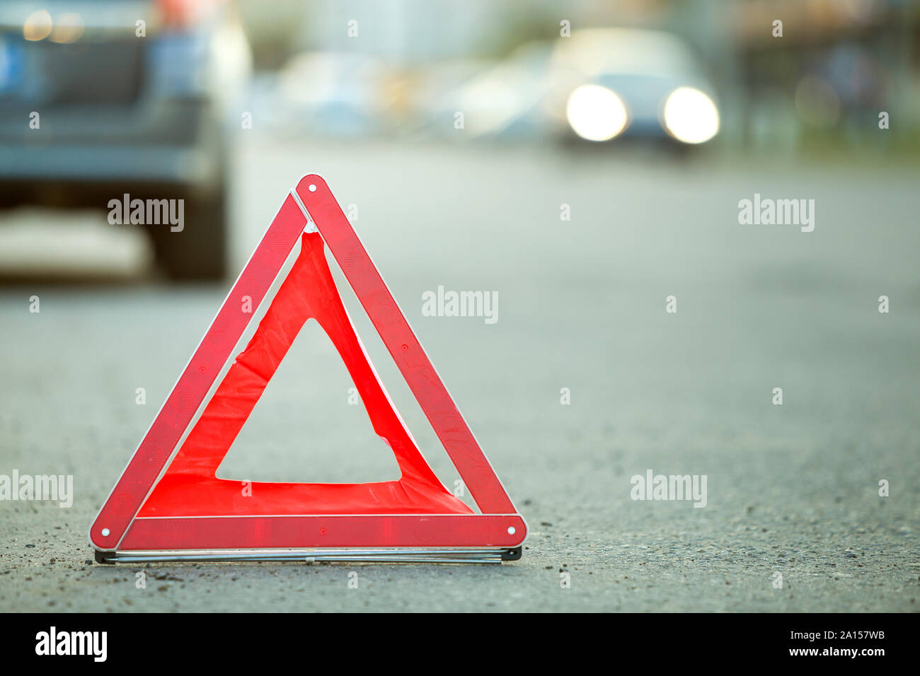 Red emergency triangle stop sign and broken car on a city street Stock ...