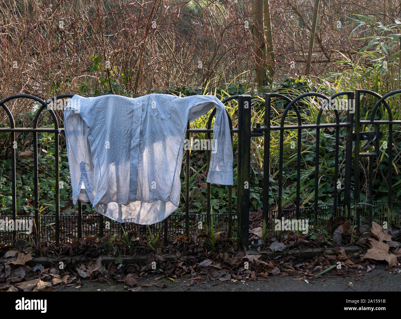 An abandoned shirt draped over a railing Stock Photo - Alamy