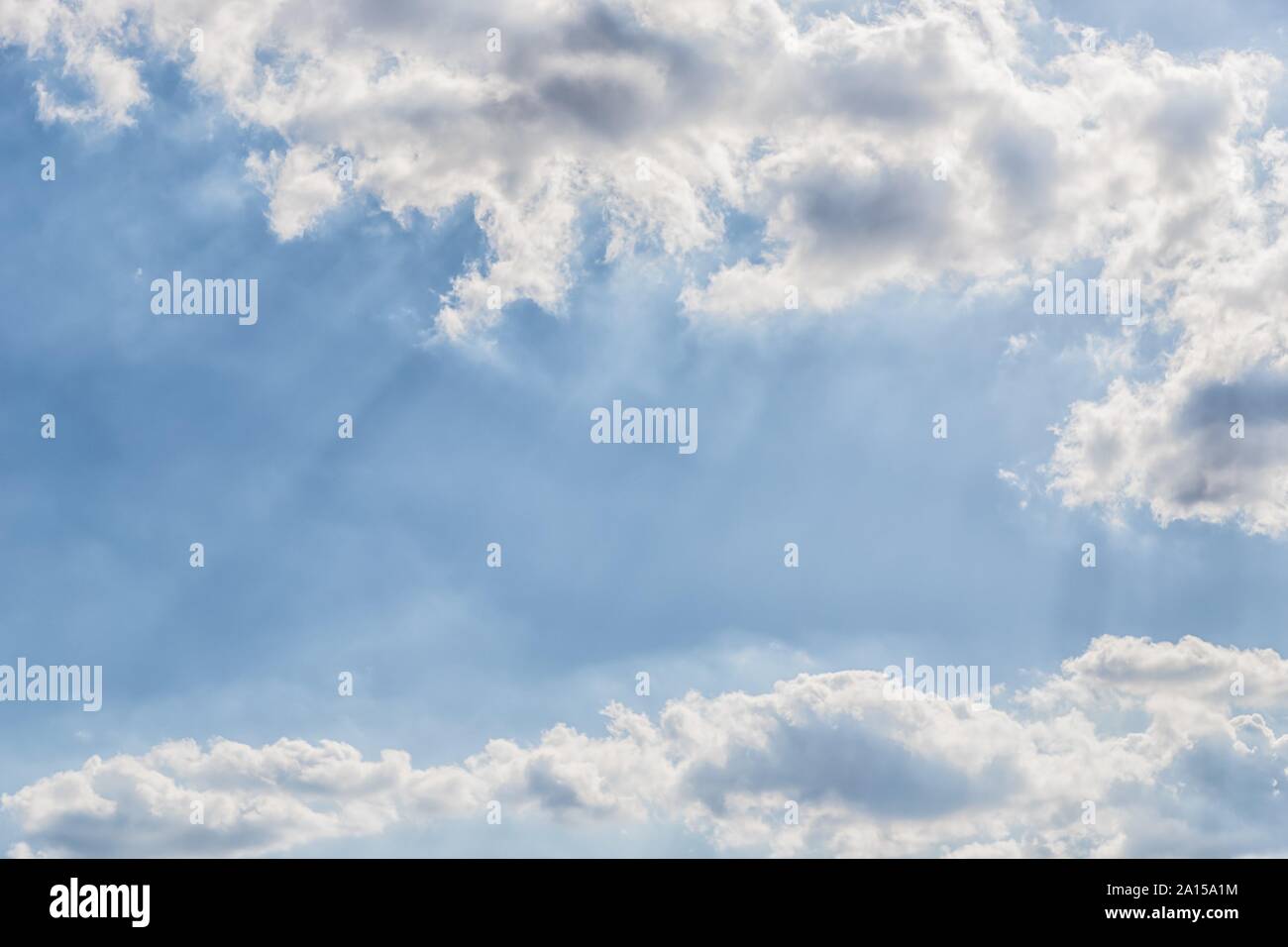 Delicate light rays through clouds on pastel blue color sky background ...