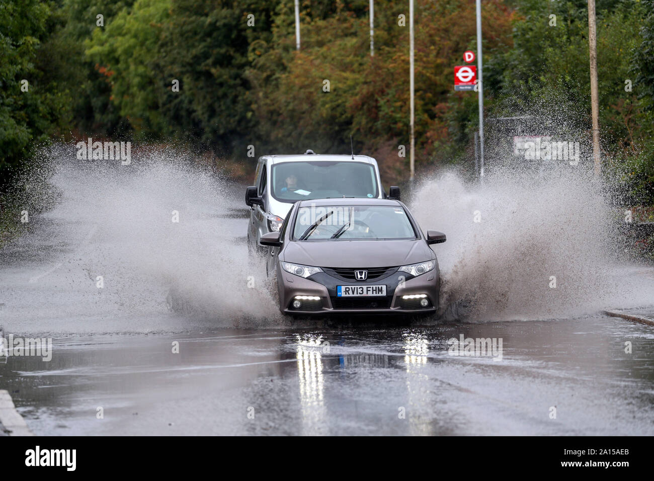 Vehicles go through a partially flooded road near colnbrook hi-res ...