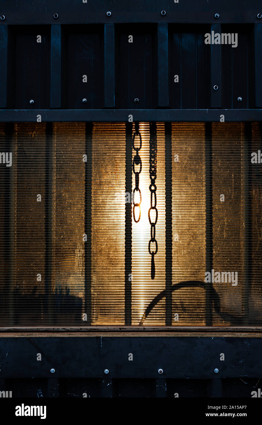 Chain hanging in the window of a steel clad building Stock Photo - Alamy