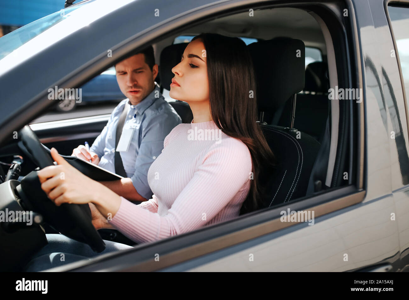 Male auto instructor takes exam in young woman. She hold hands on ...