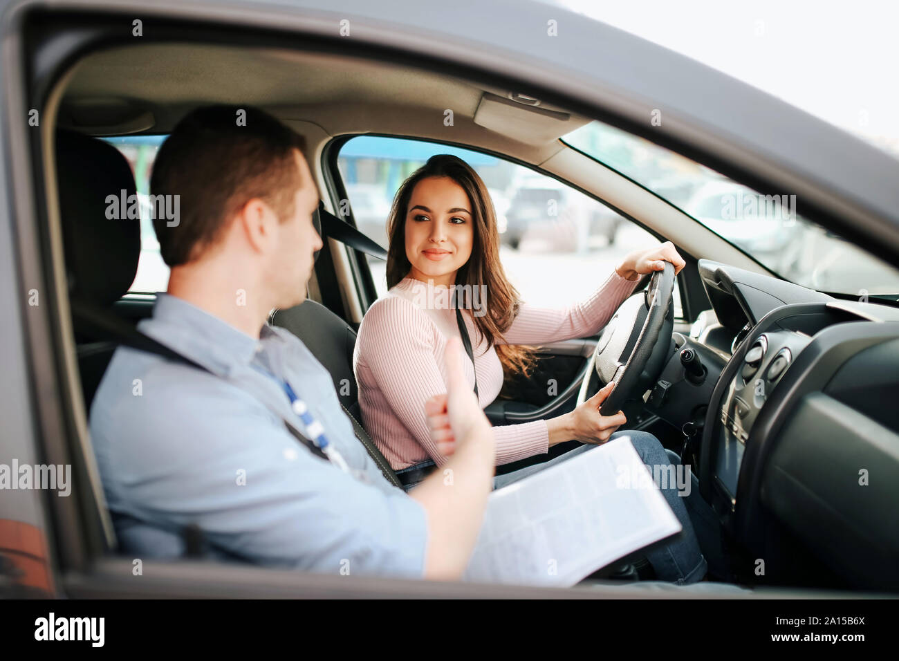 Male auto instructor takes exam in young woman. Positive happy model ...