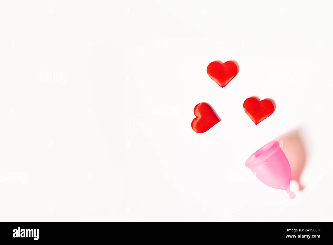 Reusable menstrual cup and red hearts on white background Stock Photo ...