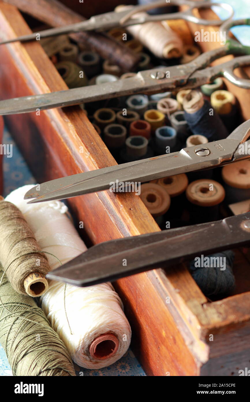 Sewing box with many thread spools and vintage scissors. Tailor ...