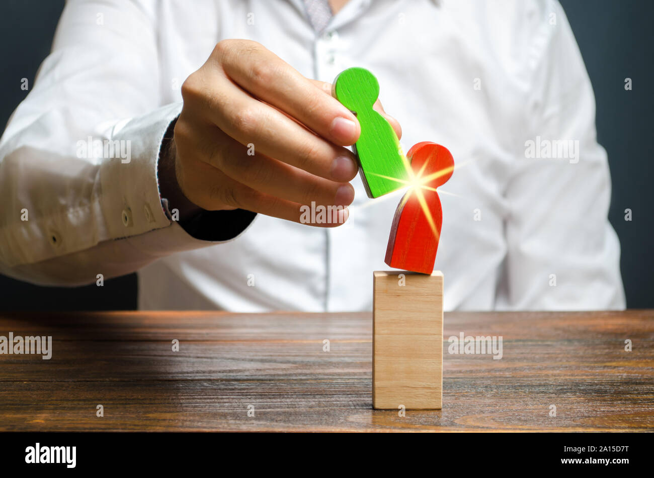 A person replaces a red human figure with a green one. firing staff ...