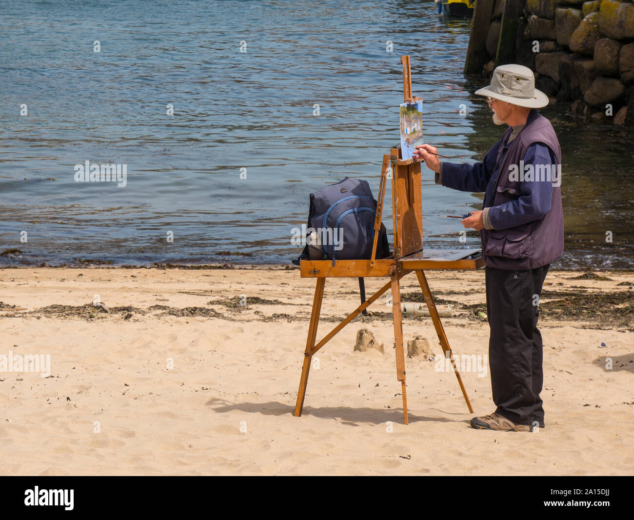 An artist on the beach in Cornwall with an easel Stock Photo - Alamy