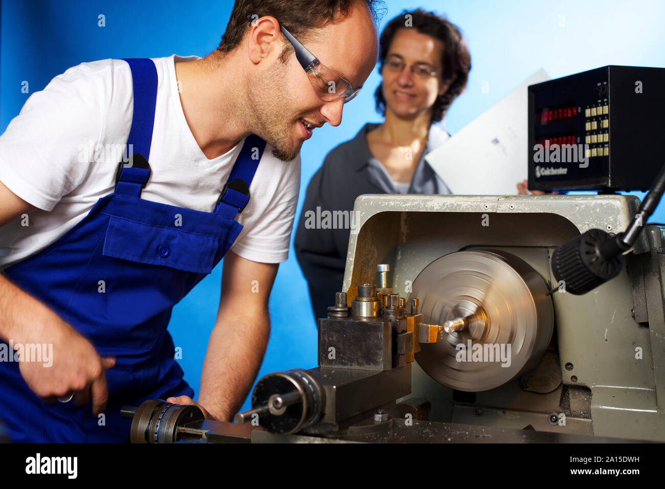 Two technicians on lathe machine in workshop Stock Photo - Alamy