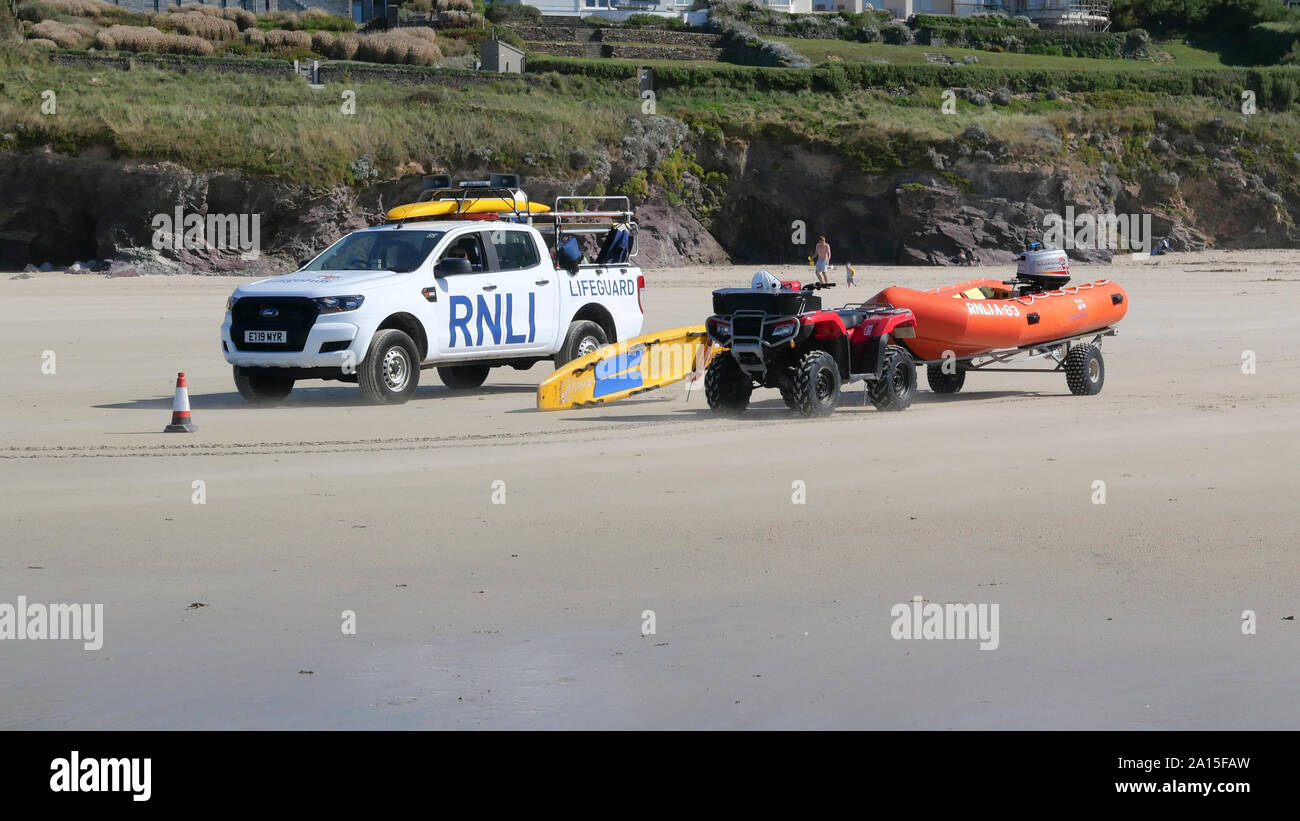 RNLI lifeguards on watch on the beach with a pick-up truck and a quad ...