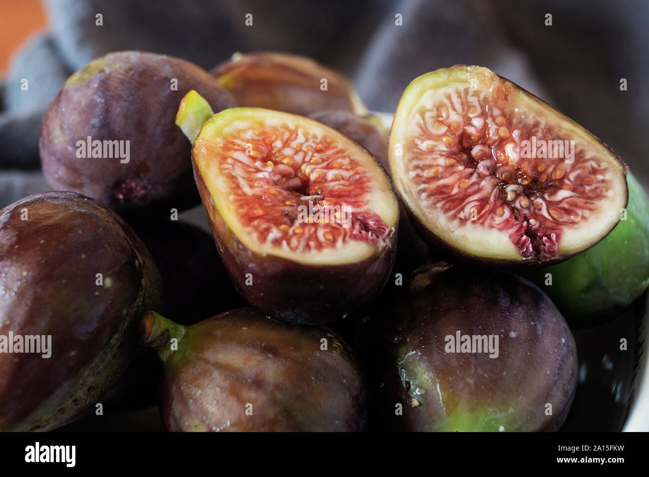 Whole figs and one fig sliced in half, close up Stock Photo - Alamy