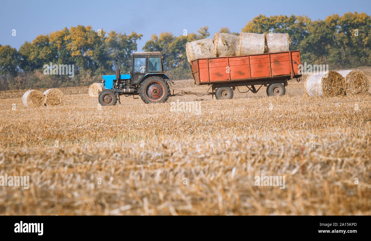 Hay bail harvesting in wonderful autumn farmers field landscape with ...