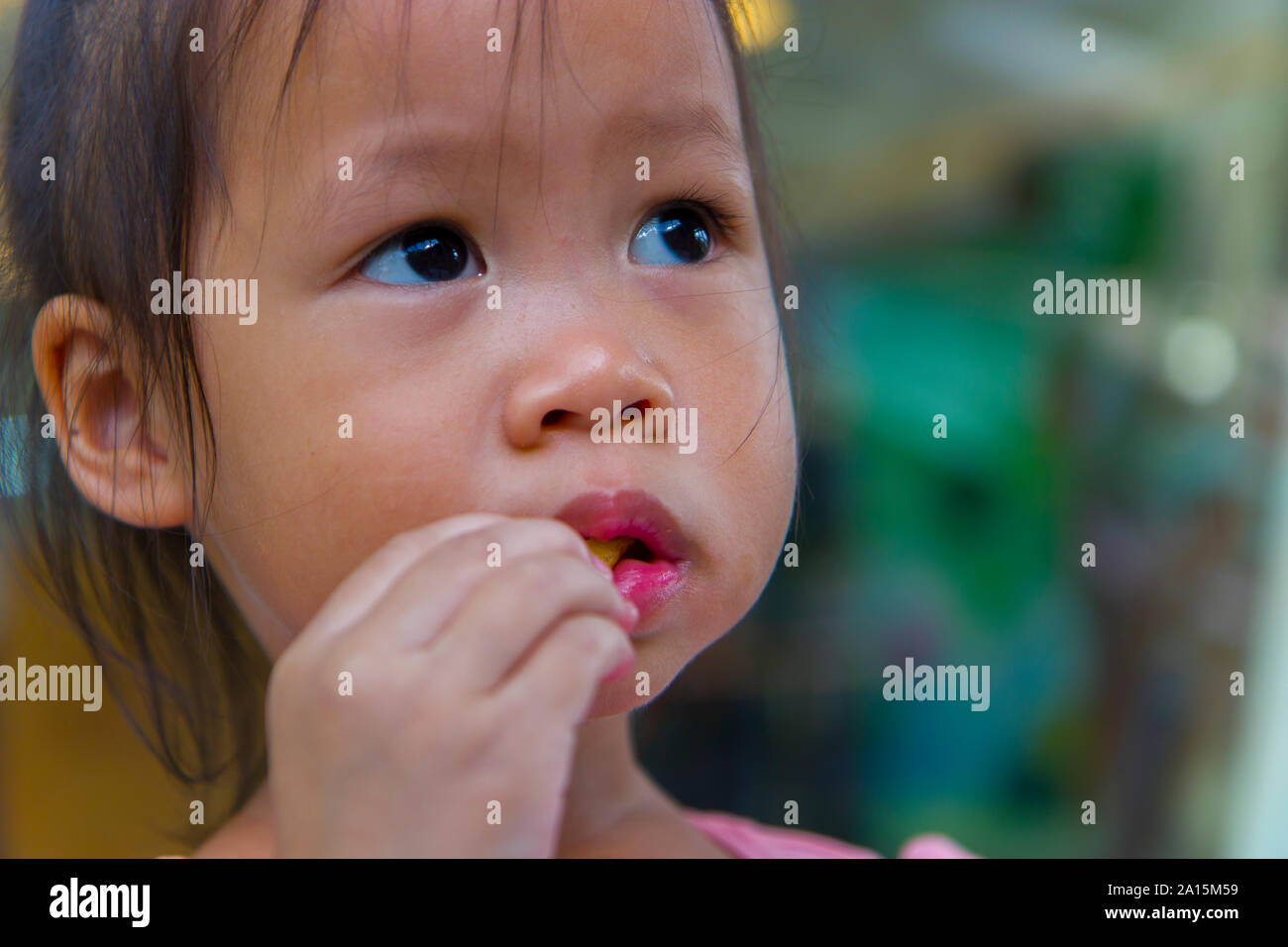 Adorable asian child smiling and enjoy eating breaded sticks at ...