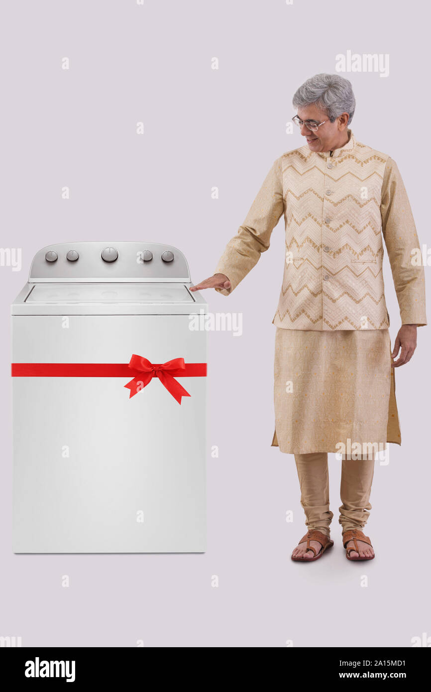 Full length portrait of a old man standing by a washing machine Stock ...