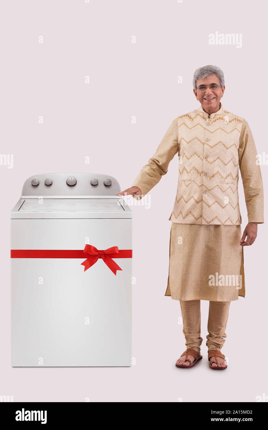 Full length portrait of a old man standing by a washing machine Stock ...
