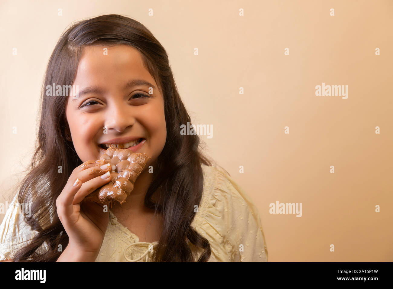 Smiling girl eating a chocolate bar Stock Photo - Alamy