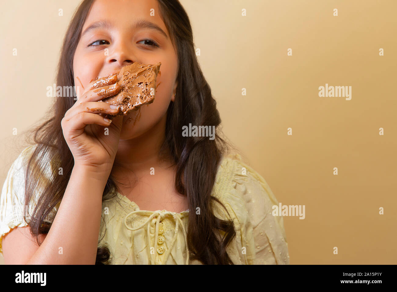 Girl eating a melting chocolate looking away Stock Photo - Alamy