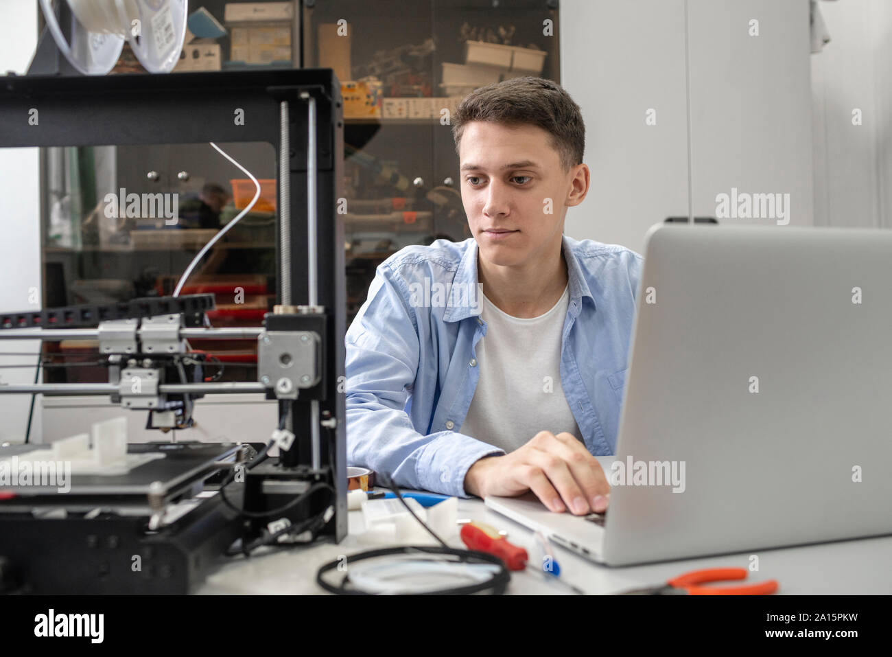 Student setting up 3D printer, using laptop Stock Photo - Alamy