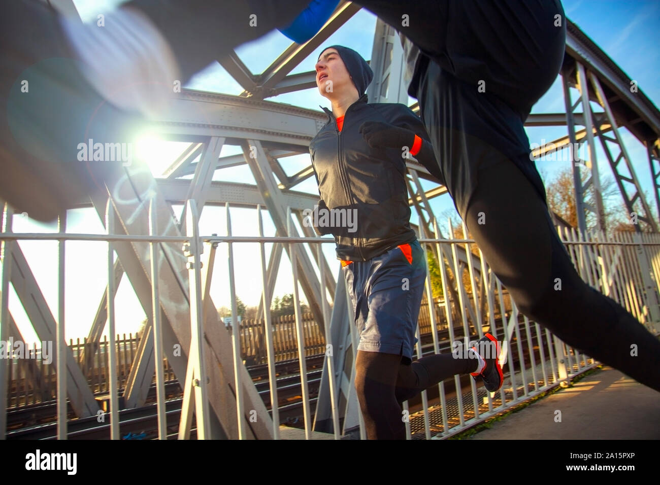 Two teenagers running over railway bridge Stock Photo - Alamy