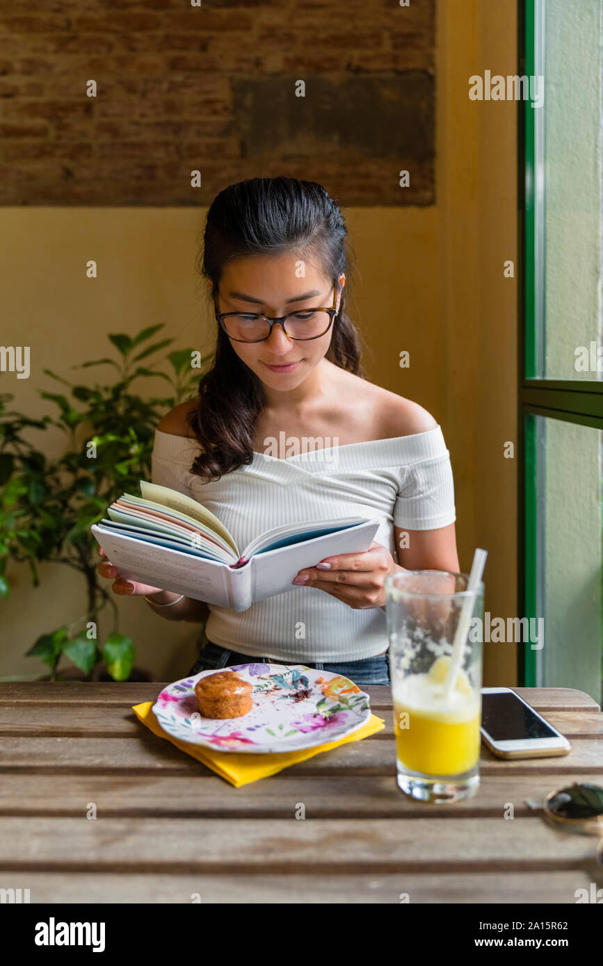 Woman reading sitting table hi-res stock photography and images - Alamy