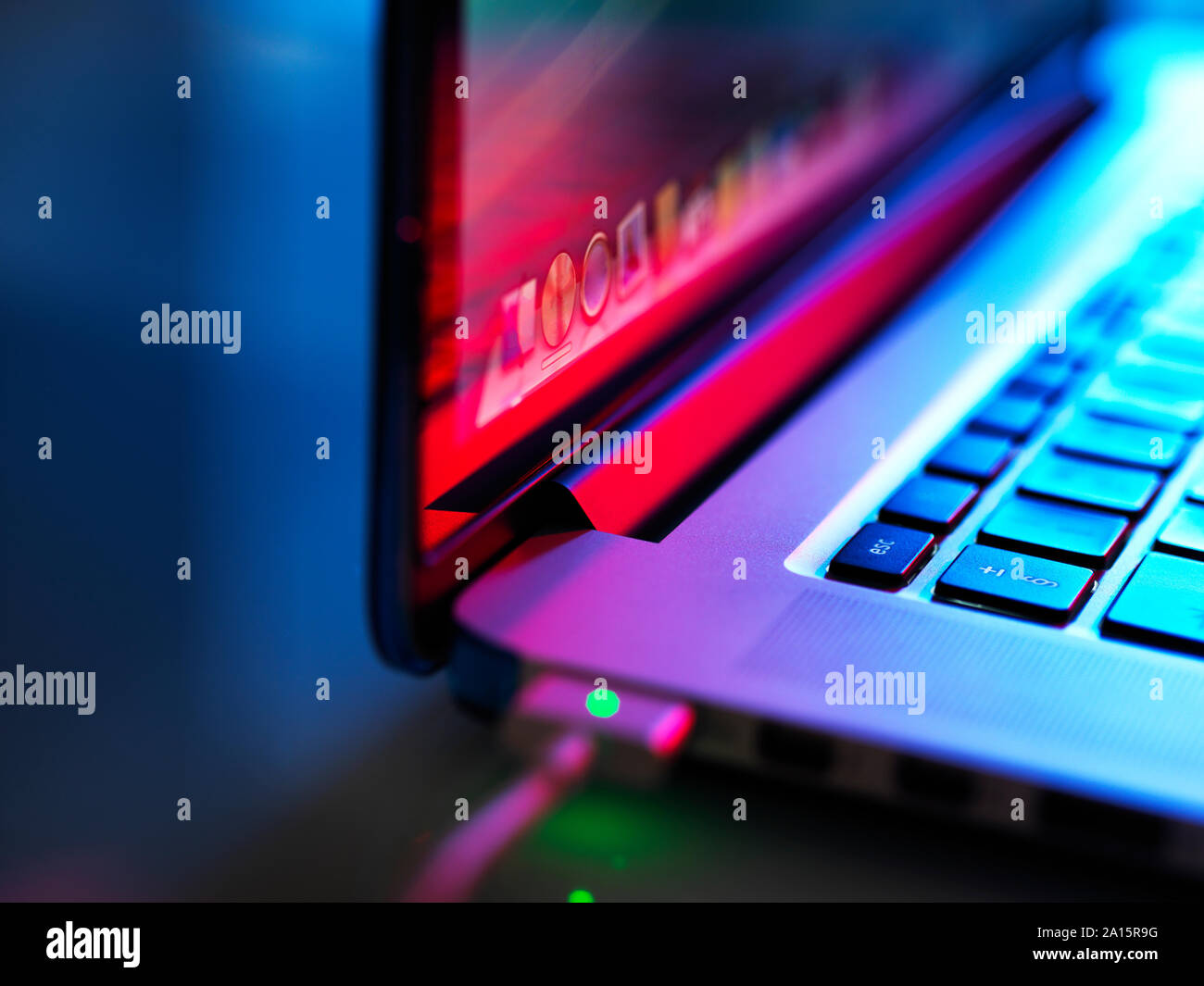 Laptop computer open and on at night Stock Photo - Alamy