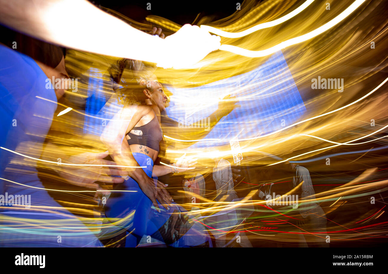 Long exposure photo of two women running in the city at night Stock ...