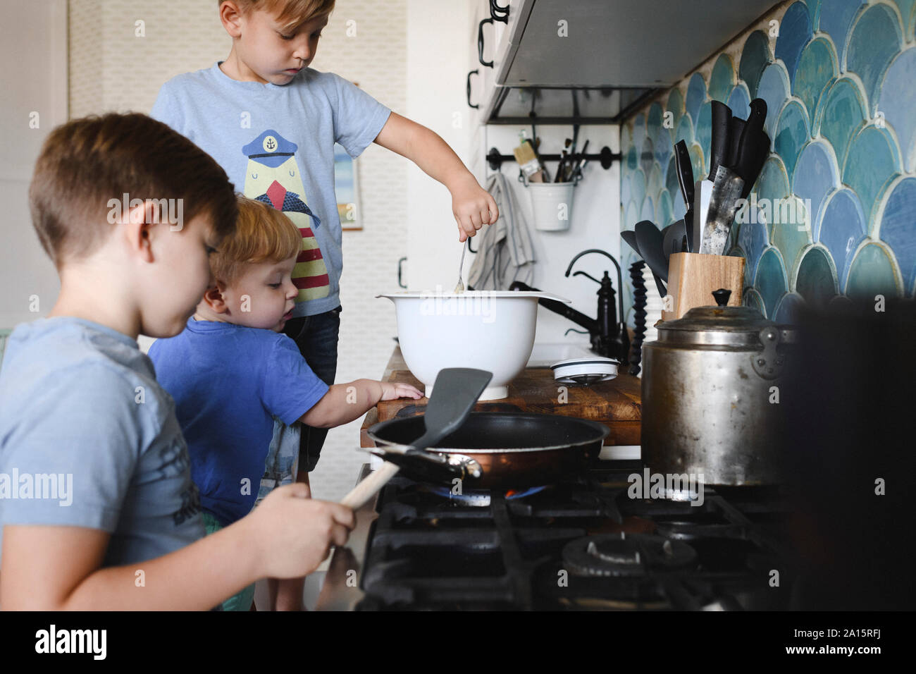 Three brothers cooking pancakes in the kitchen Stock Photo - Alamy