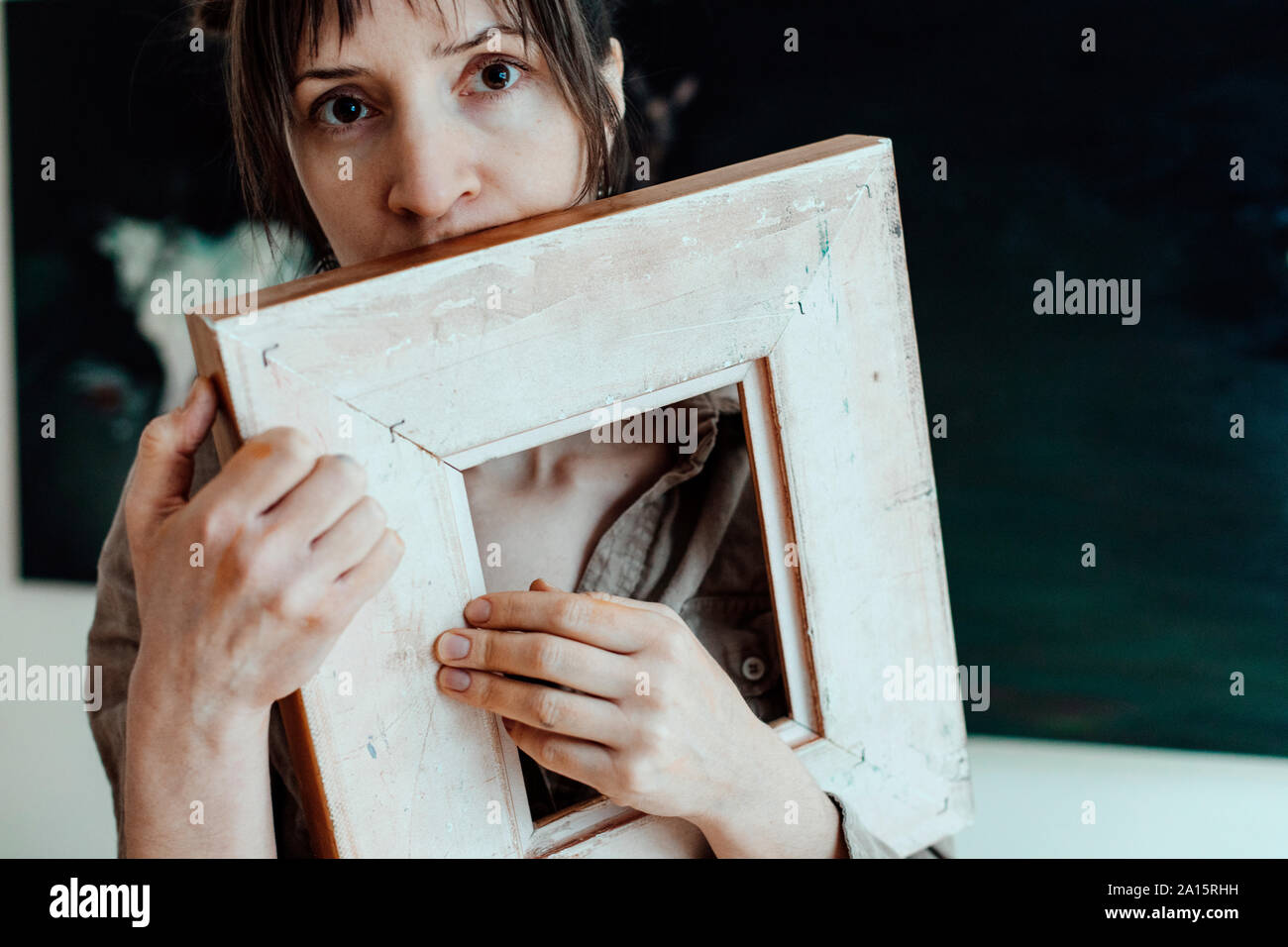 Portrait of a female painter in her studio holding picture frame Stock ...