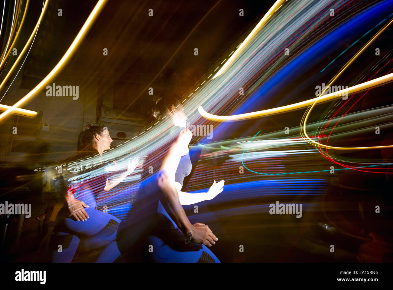 Long exposure photo of two women running in the city at night Stock ...