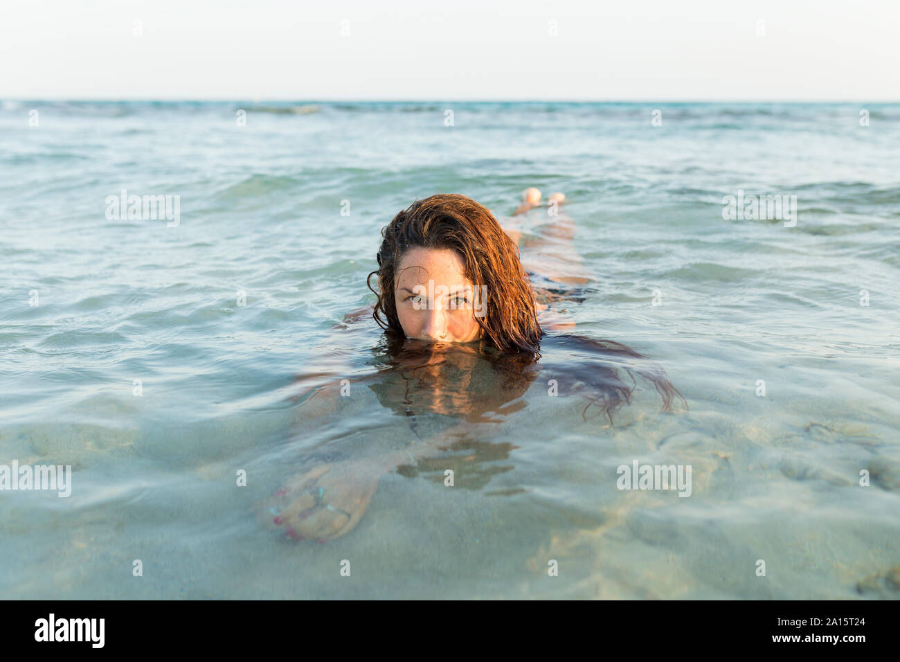 Young woman lying in water Stock Photo - Alamy