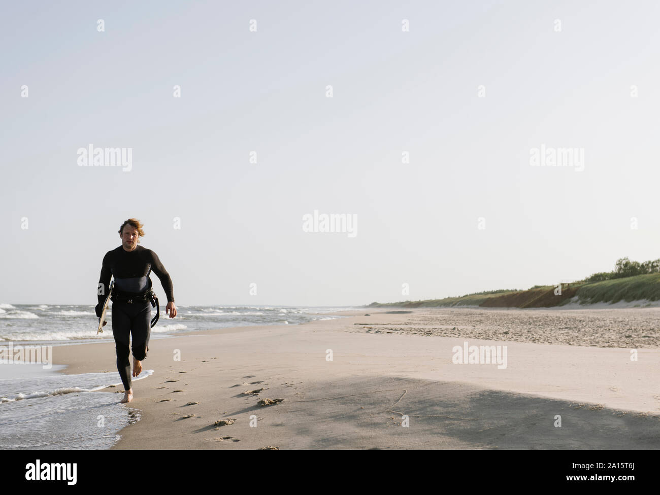 Surfer running at the beach Stock Photo - Alamy
