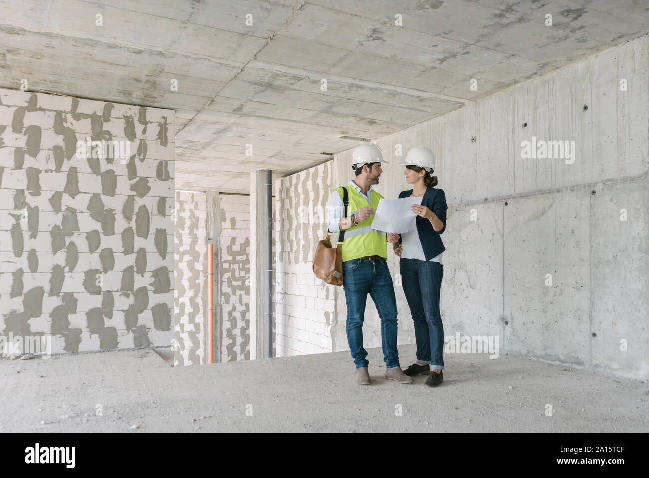Male architect and female manager talking at construction site Stock ...