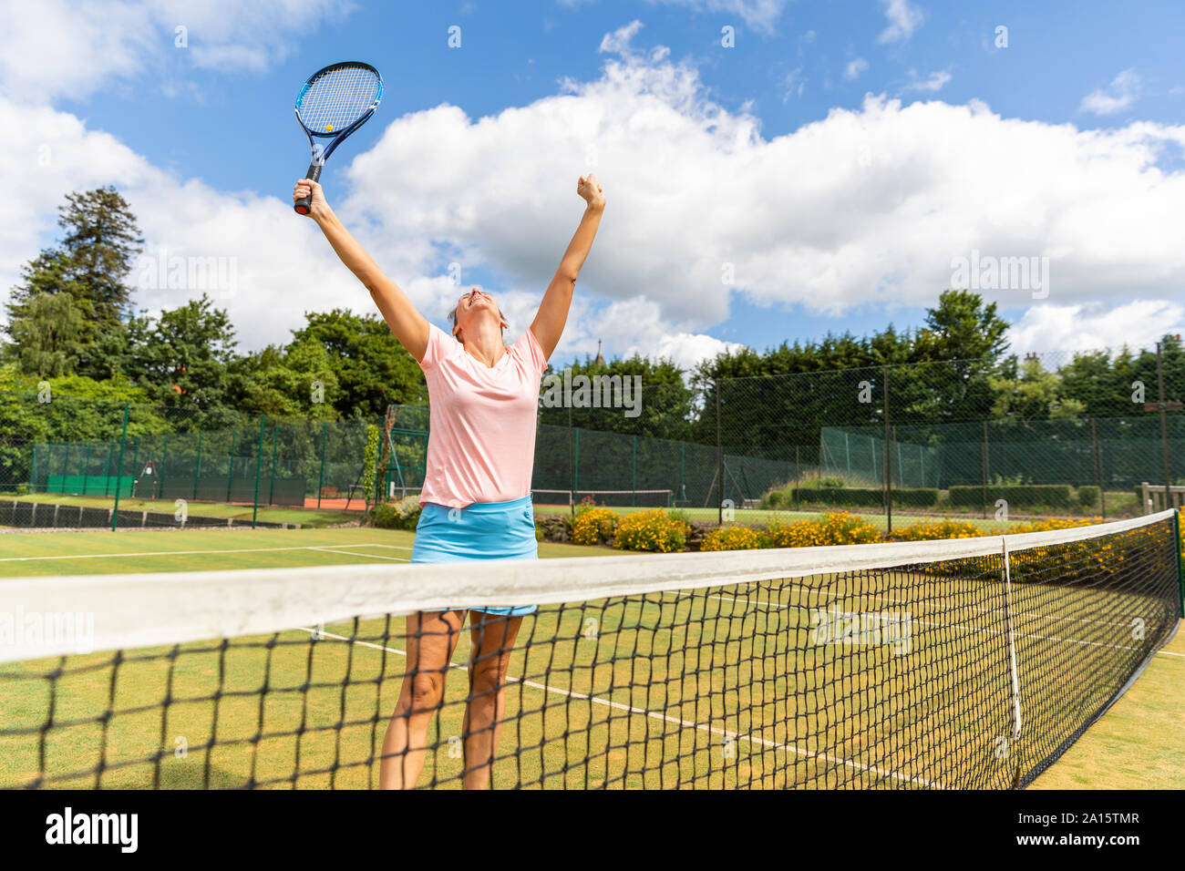 Happy female tennis player celebrating the victory on grass court Stock ...