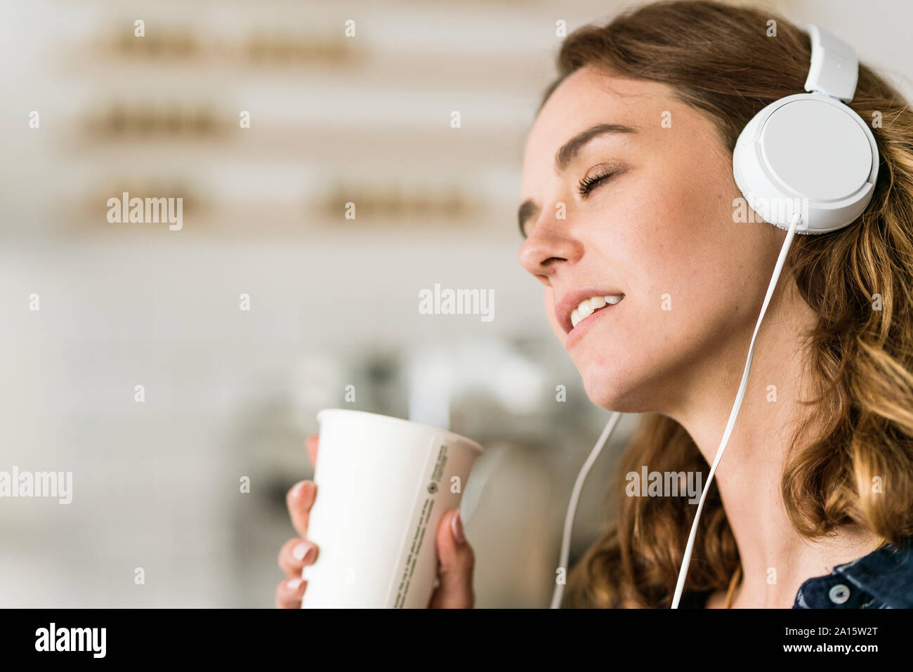Blond woman in coffee shop with headphones hi-res stock photography and ...