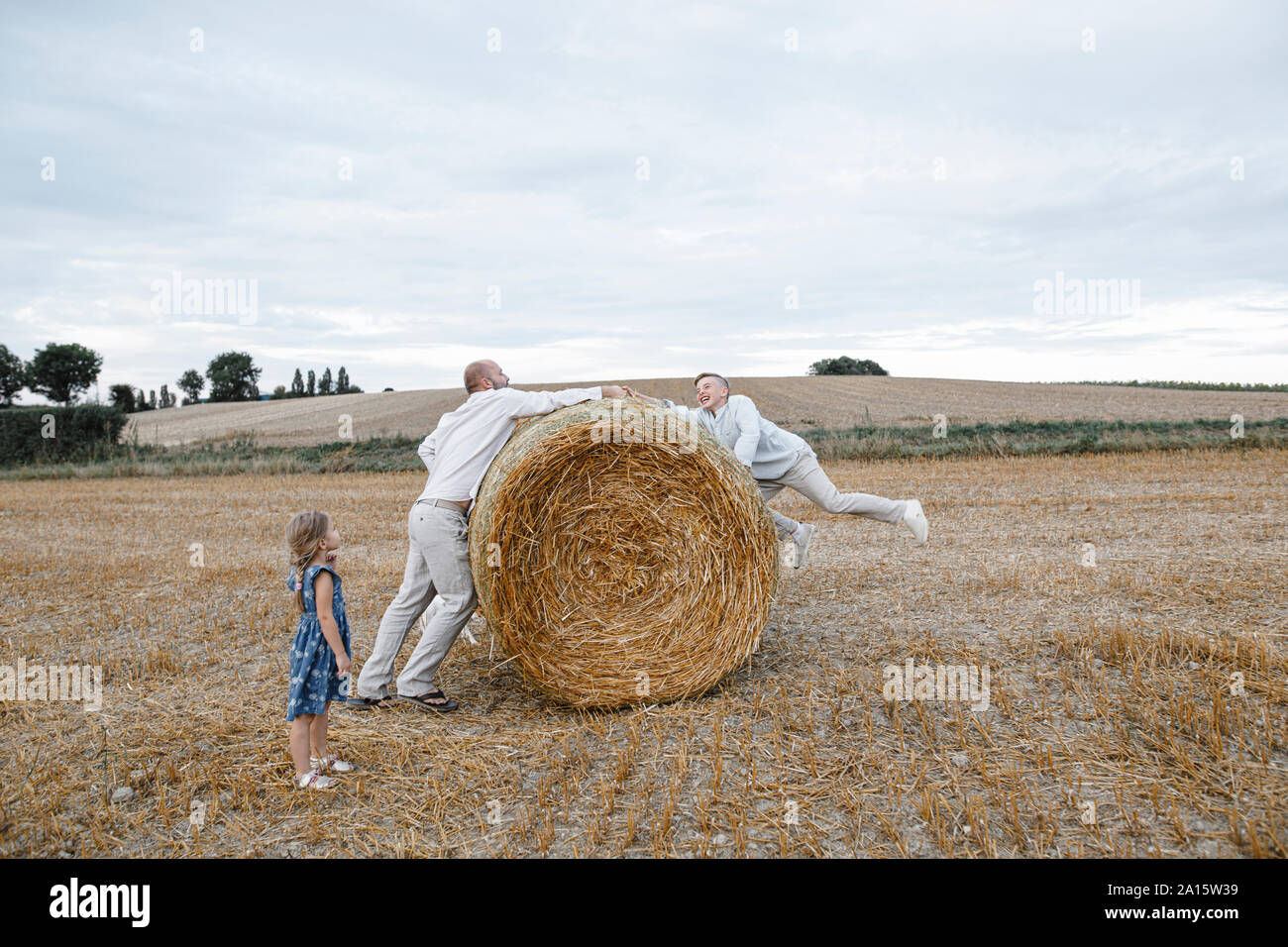 Father and his children playing on hay bales Stock Photo - Alamy