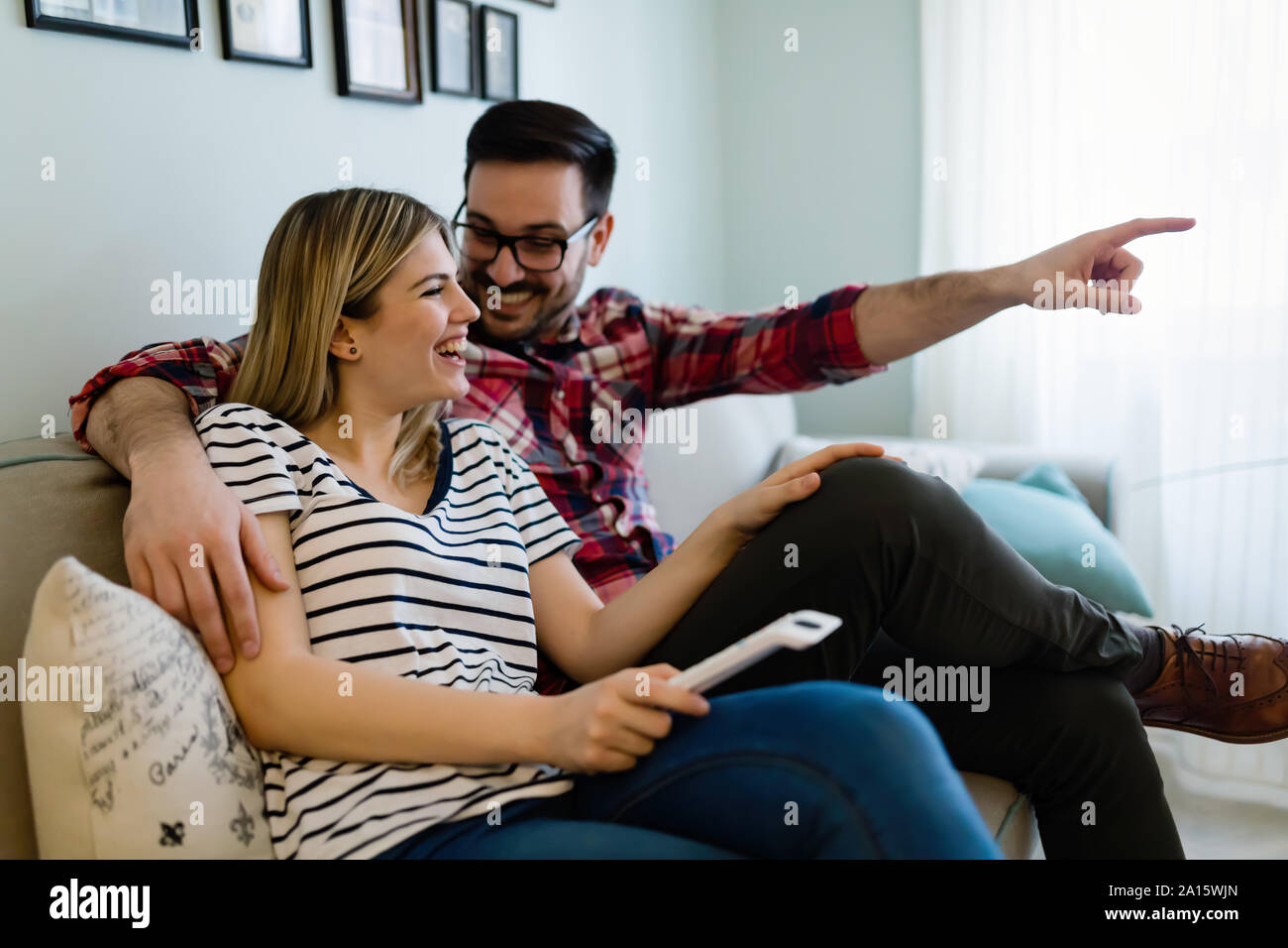 Happy couple watching tv in their house Stock Photo - Alamy