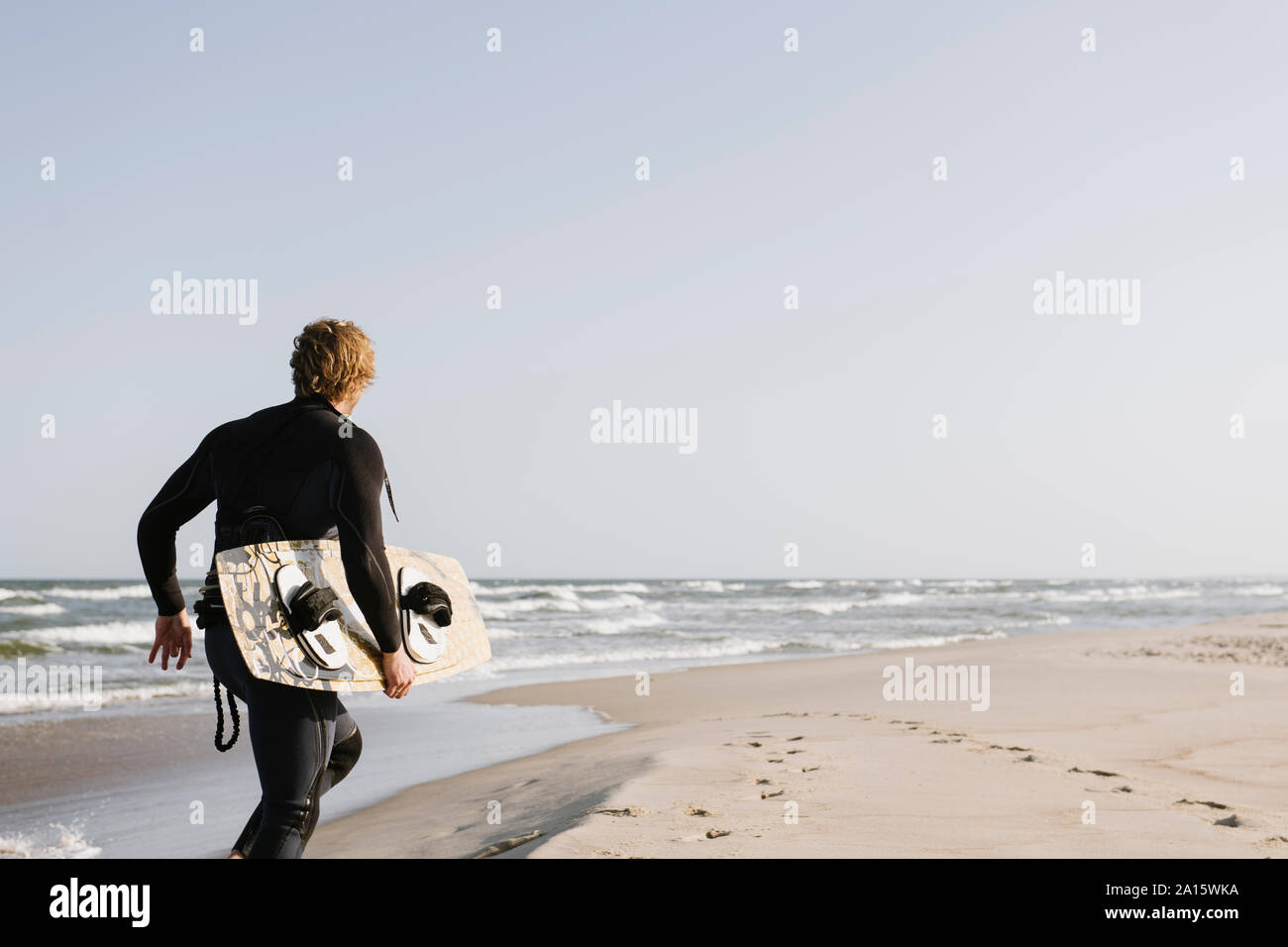 Surfer running at the beach Stock Photo - Alamy