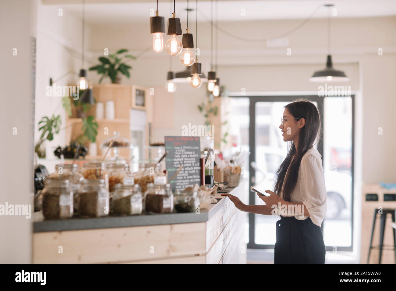 Woman standing in a cafe hi-res stock photography and images - Alamy