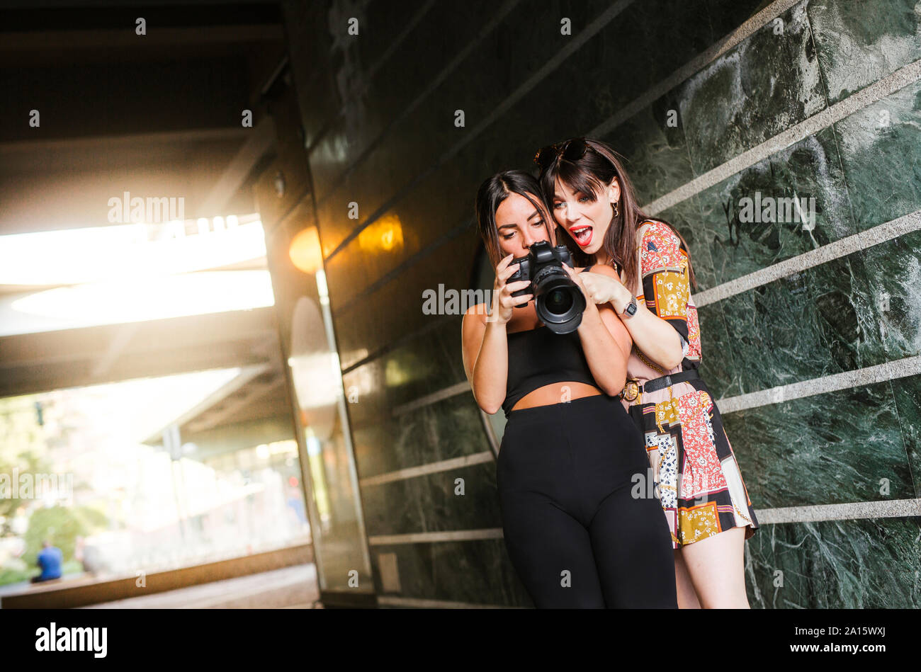 Two young woman checking photos on a camera Stock Photo - Alamy